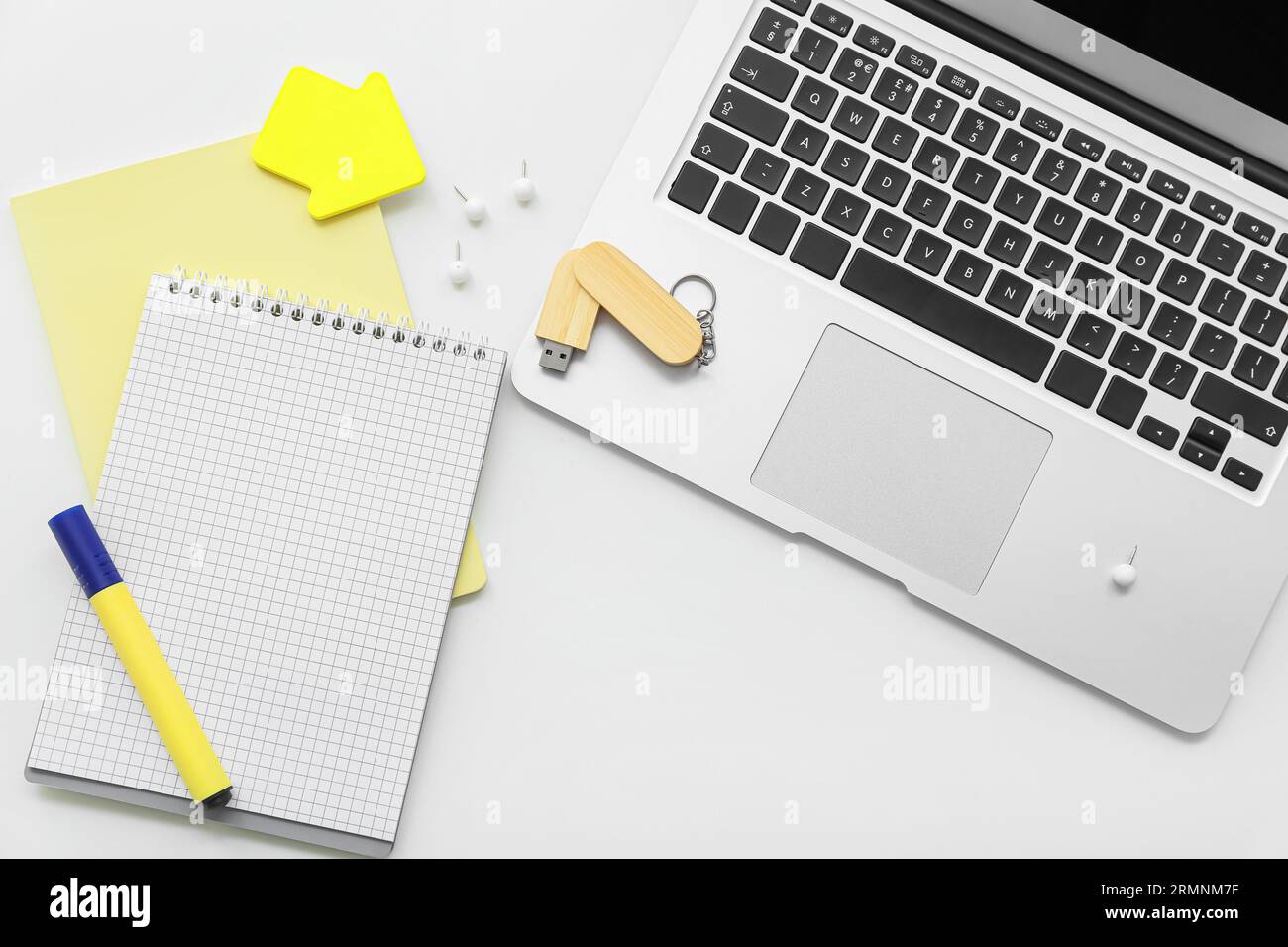 Laptop with notebooks, sticky notes and wooden USB flash driver on ...