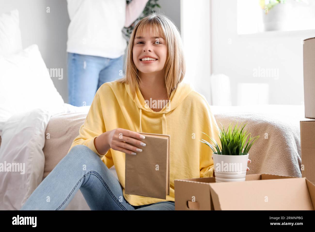 Female student unpacking things in dorm room on moving day Stock Photo ...