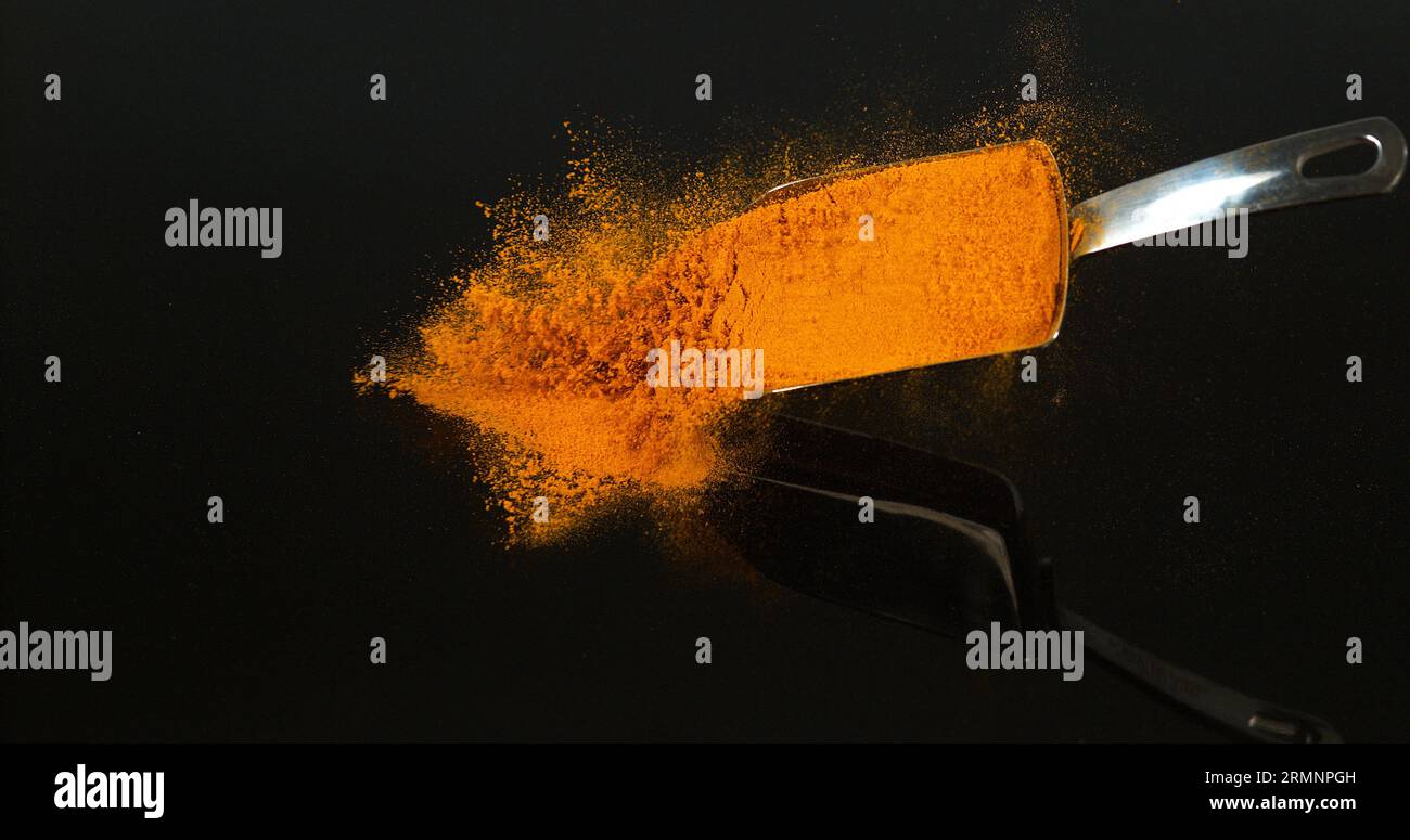 Turmeric, curcuma longa, Powder falling against Black Background ...