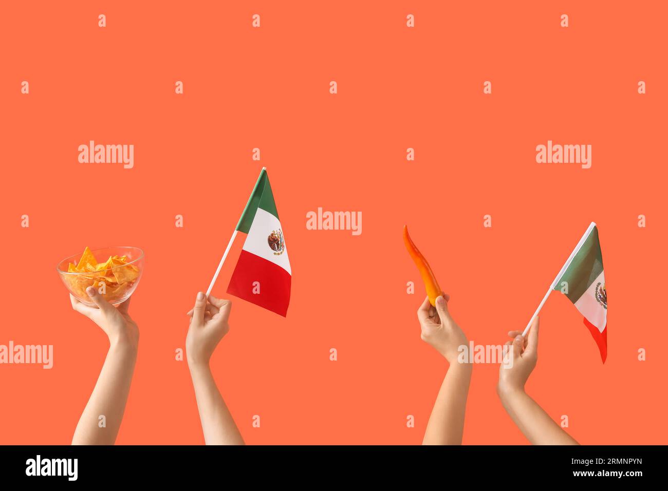 Female hands holding nachos, chilli pepper and Mexican flags on orange ...