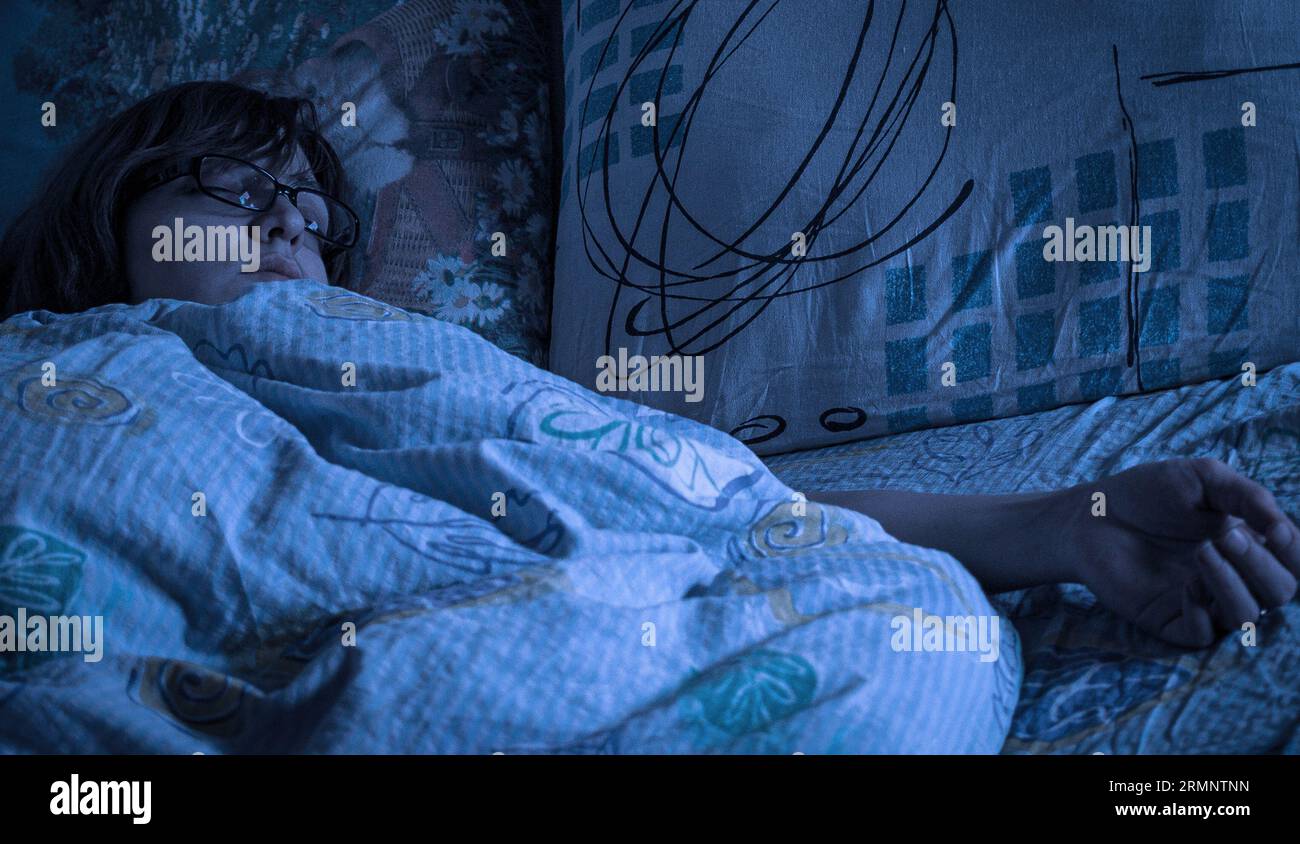 woman sleeping glasses wear in double bed at early morning or lunar ...