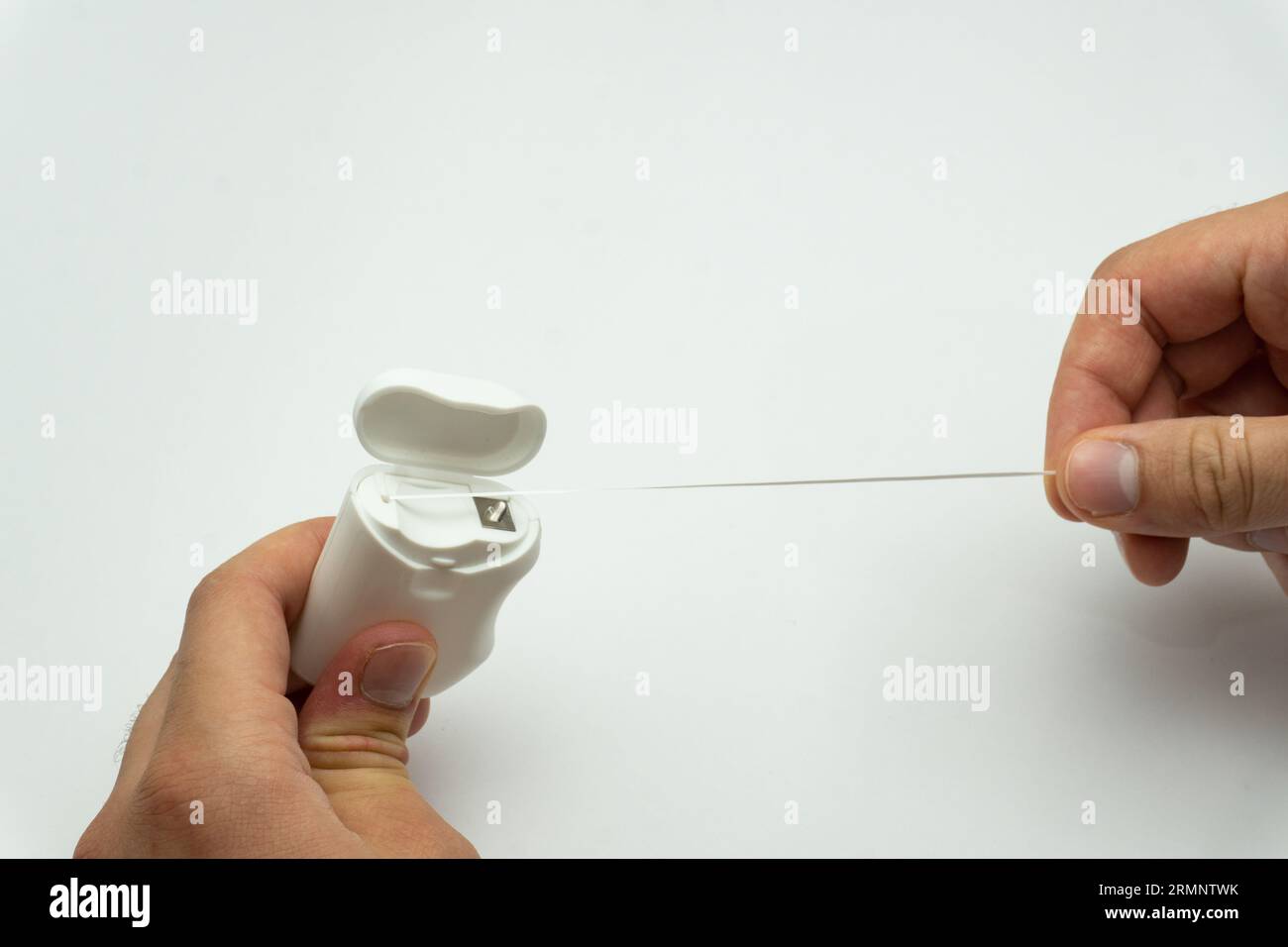Male hand holding dental floss on white background copy space Stock ...