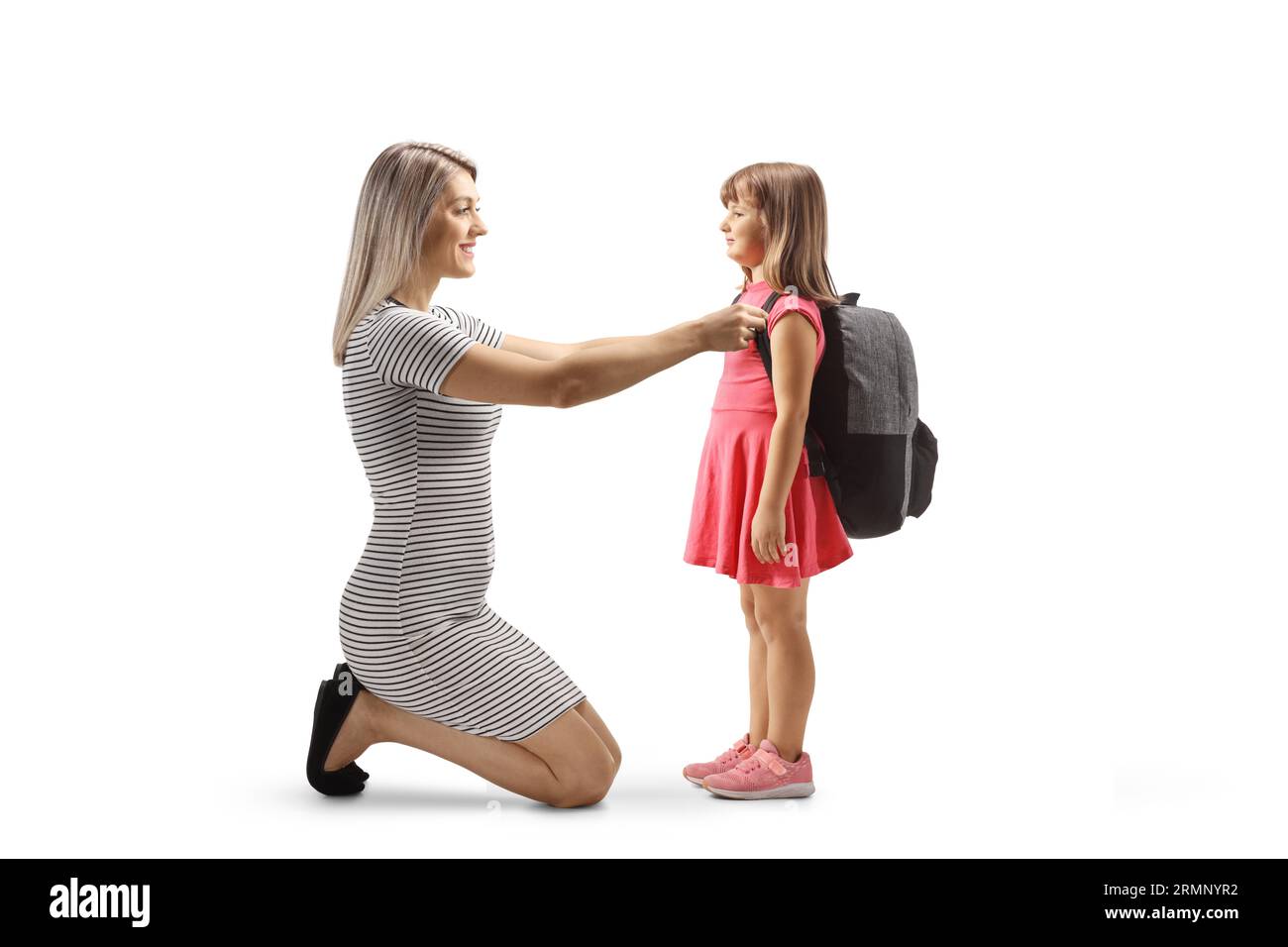 Full length profile shot of a woman helping a girl preparing for school ...