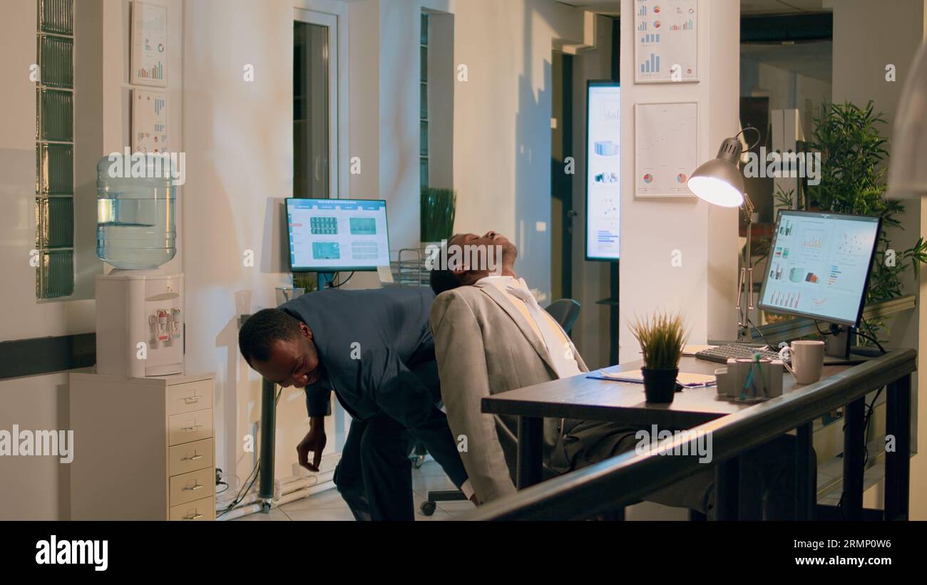 African american accountant sneaking up on sleepy coworker napping at ...