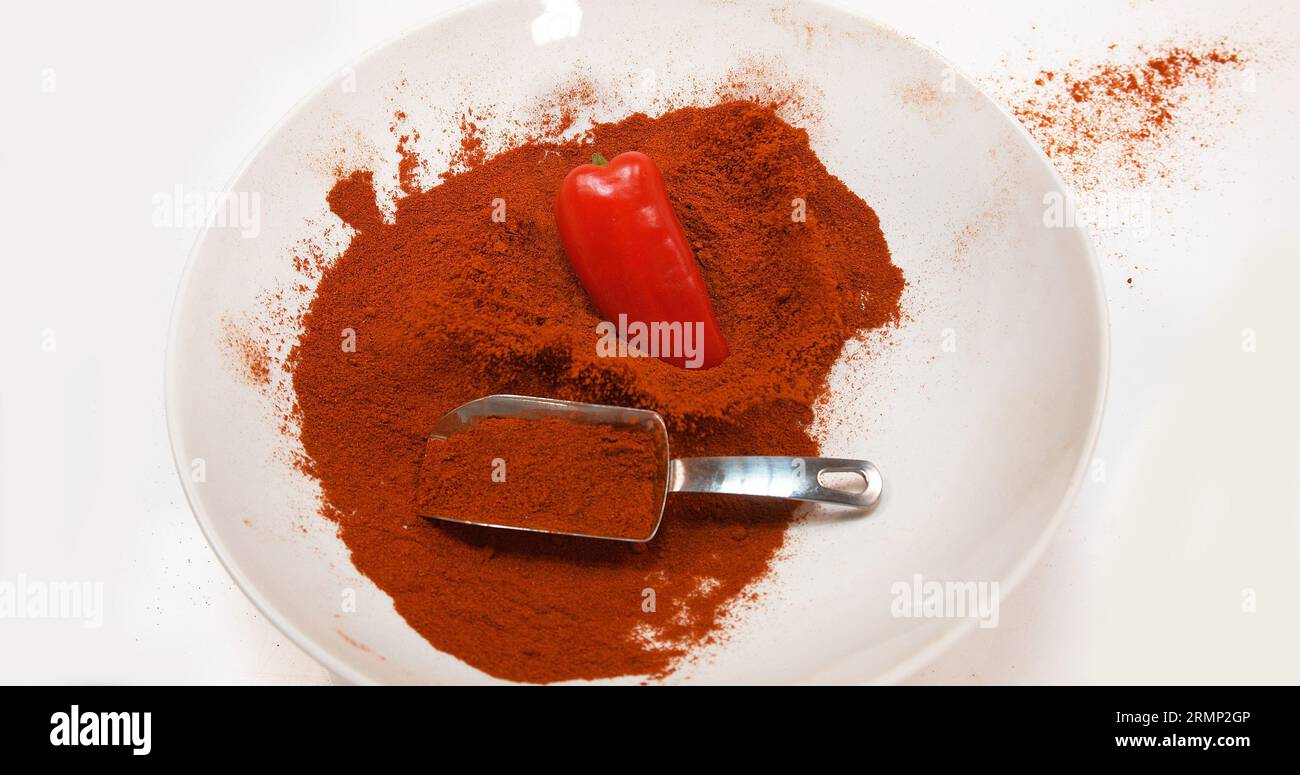 Paprika, capsicum annuum, falling into a bowl against White Background ...