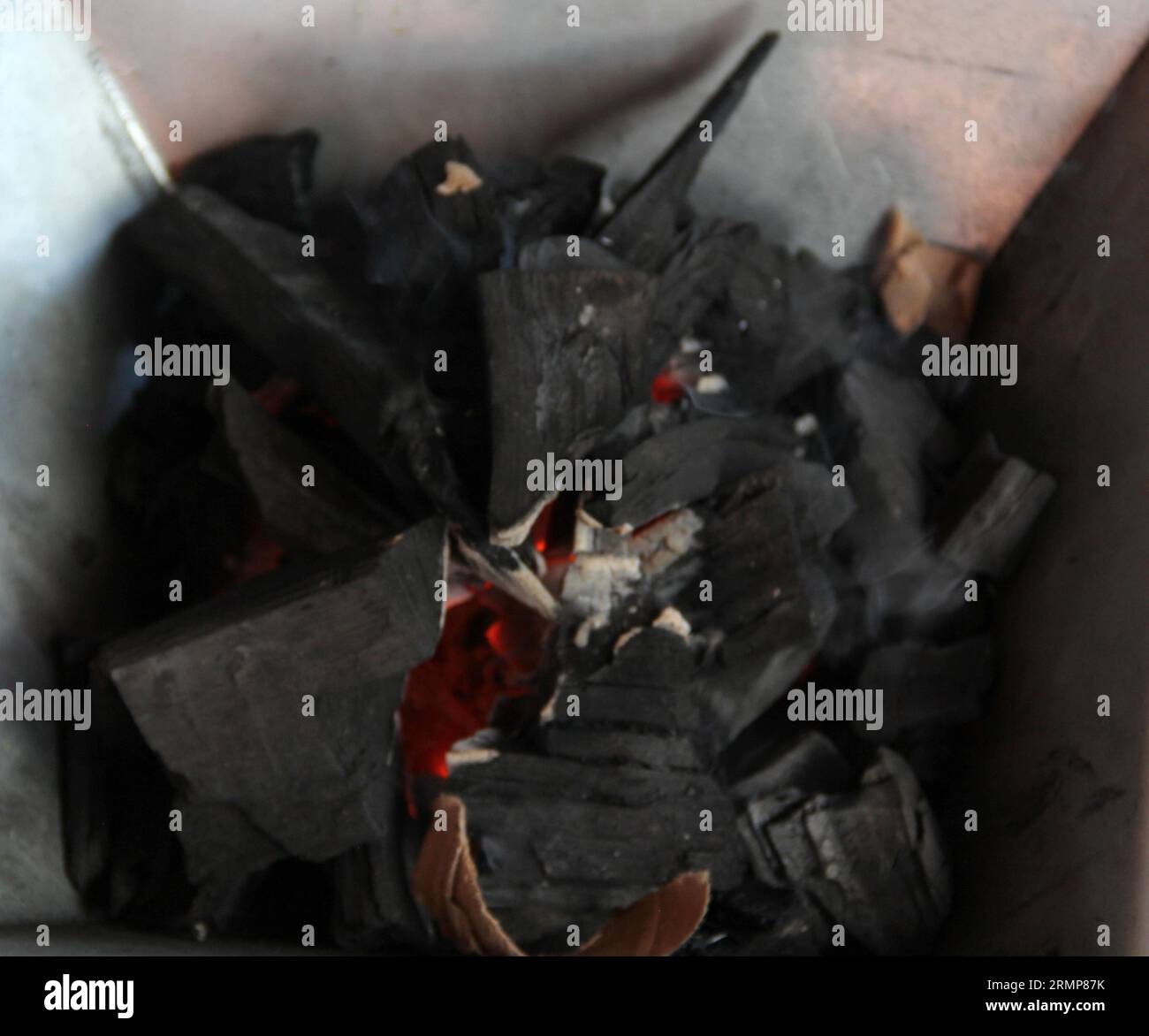 Chunks of charcoal on a grill stove starting to light a fire for ...