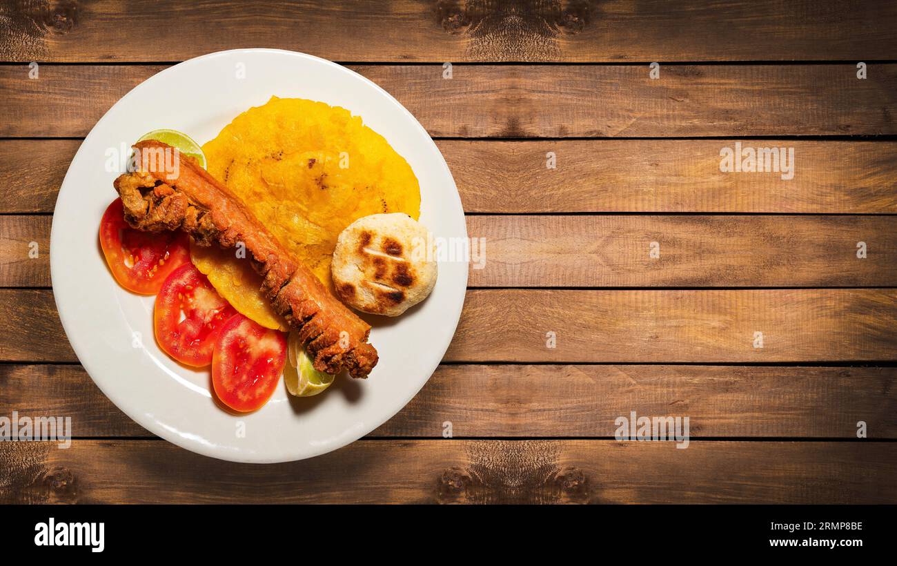 Pork chicharron with patacones and sliced tomatoes - Colombian ...