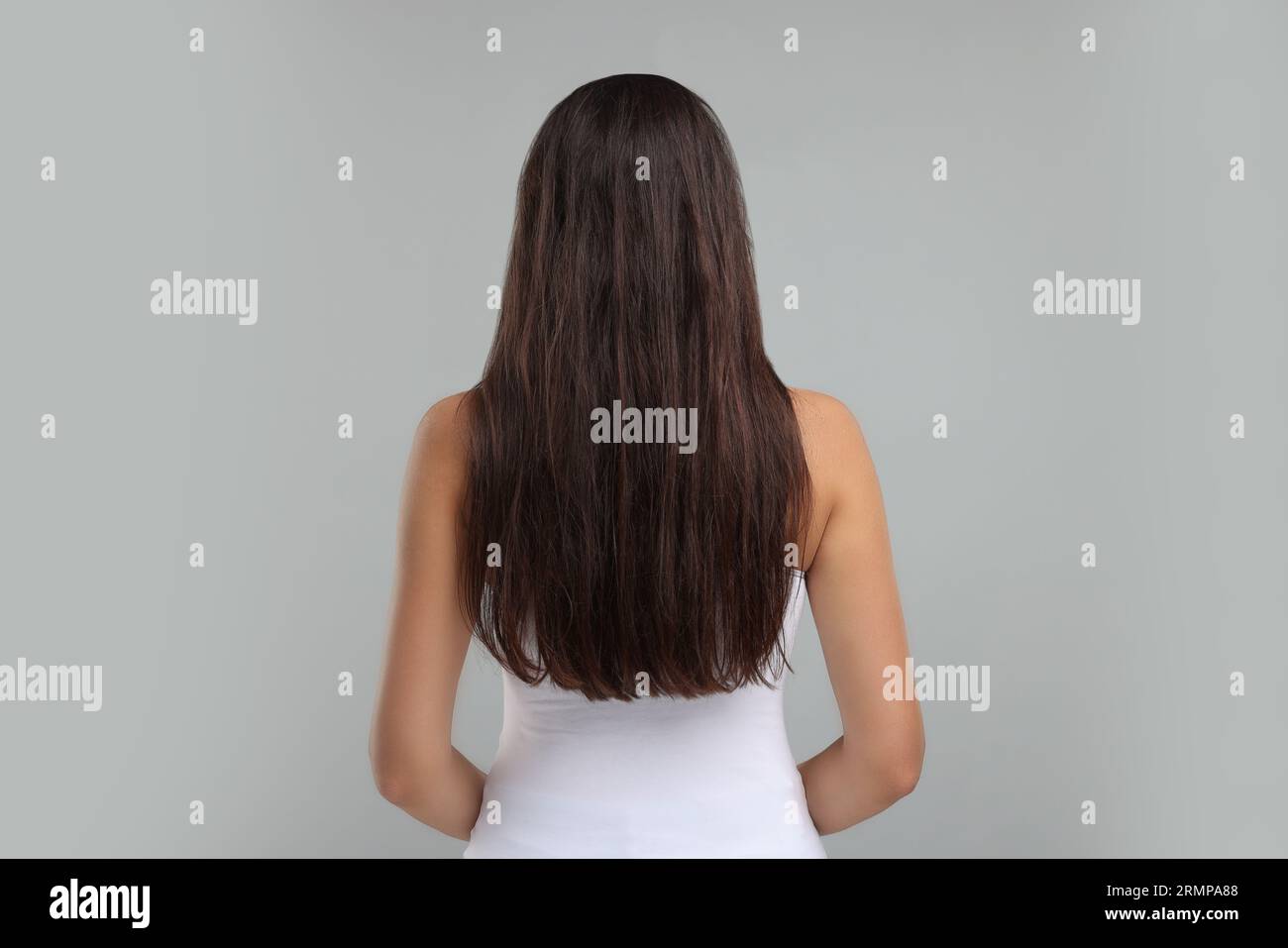 Woman with damaged messy hair on grey background, back view Stock Photo ...