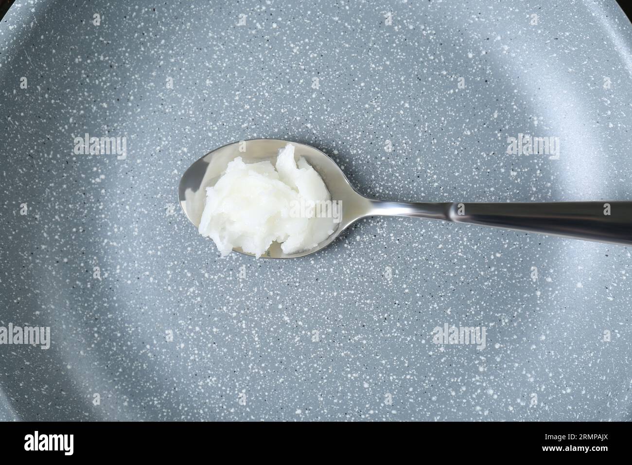 Organic coconut cooking oil and spoon on frying pan, top view Stock ...