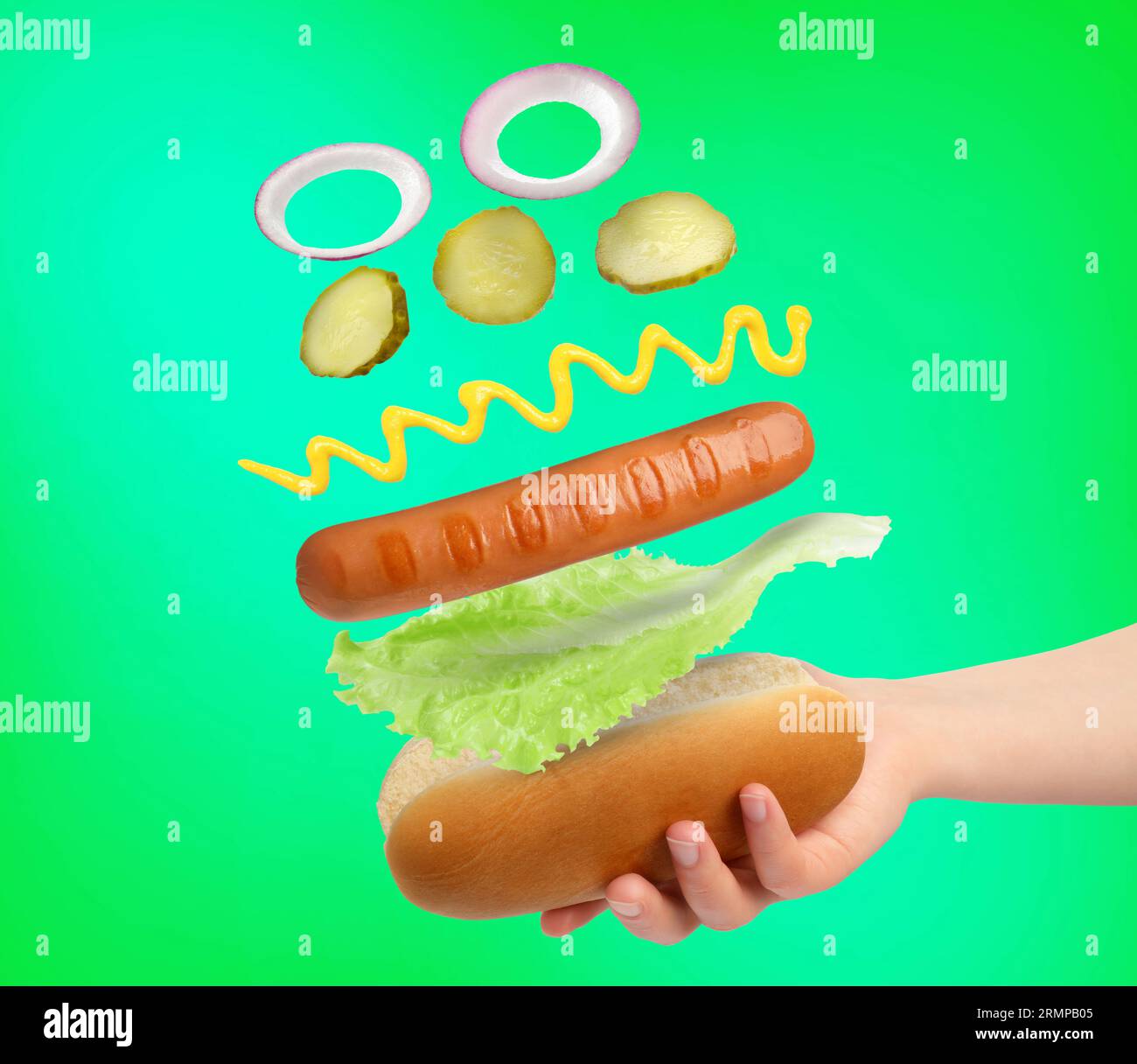 Woman making hot dog on green gradient background, closeup. Ingredients ...
