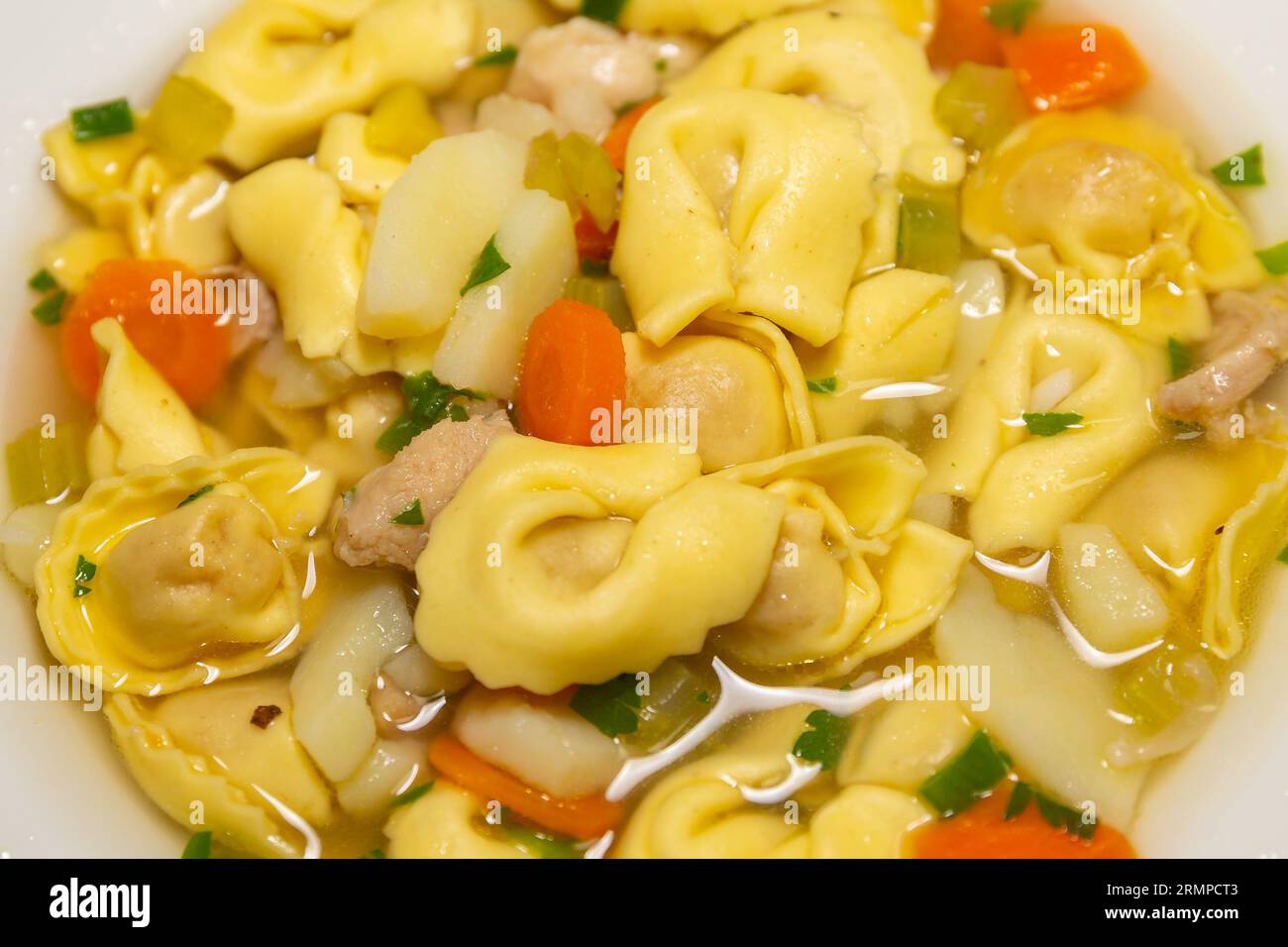 Traditional Italian tortellini (capeletti, agnolini) soup with chicken ...