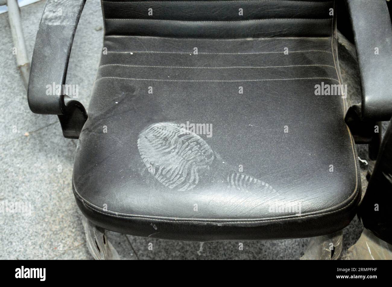 footwear impression shoe print left on a leather chair, dirty dusty ...
