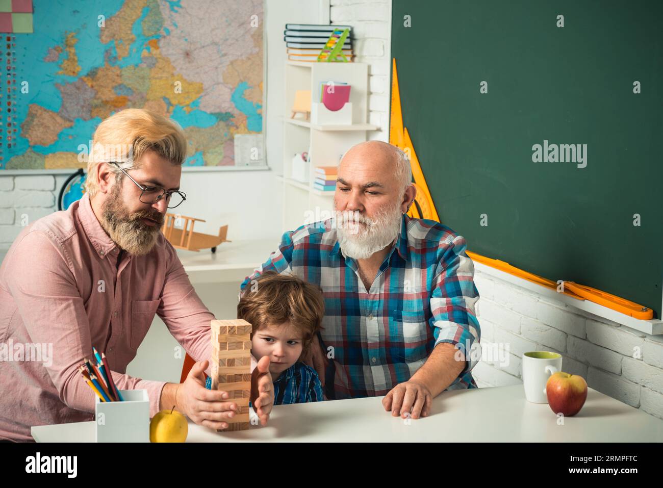 Fathers day. Grandfather father and son playing games. Grandpa teaching ...