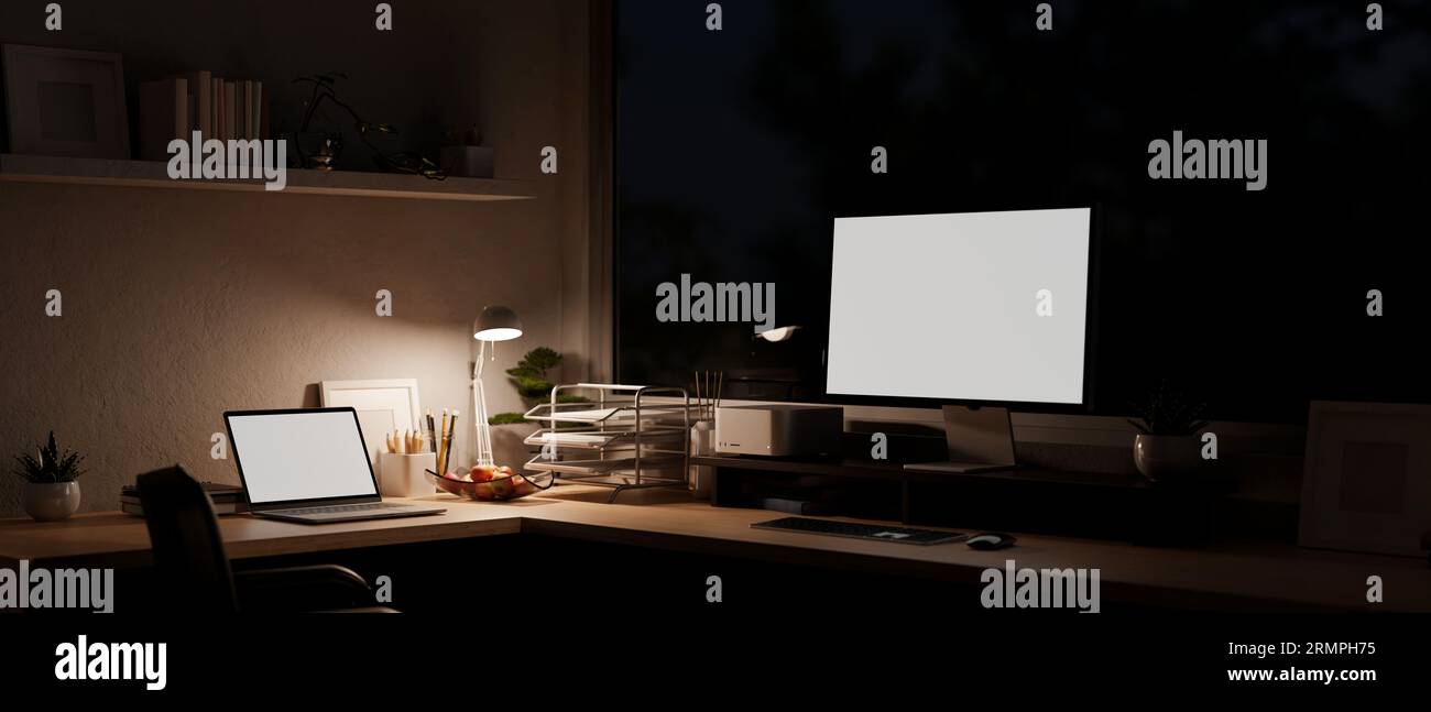 Modern office workspace at night with a computer and laptop white ...