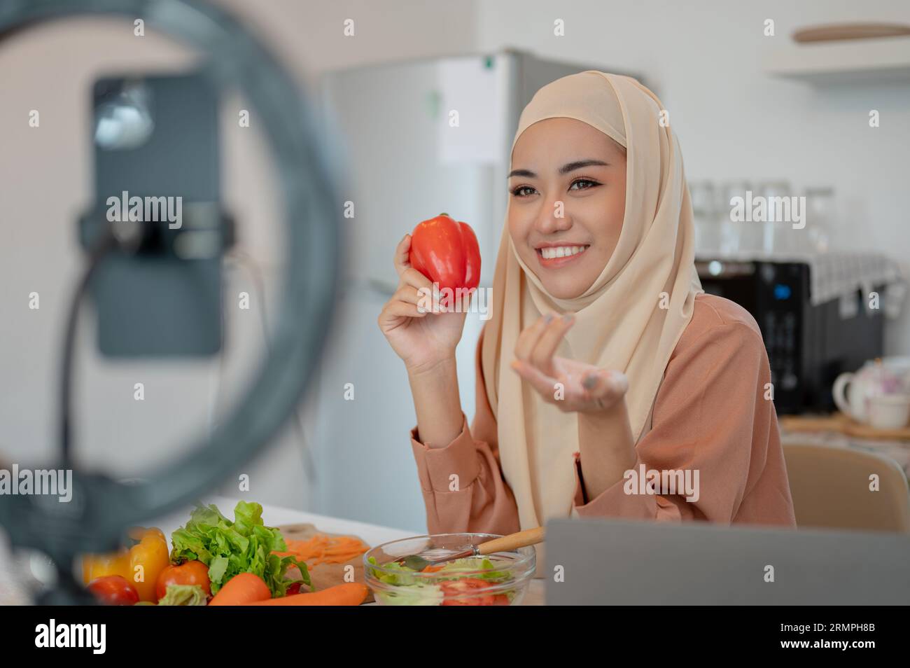 A beautiful Asian Muslim female food blogger or content creator is live ...