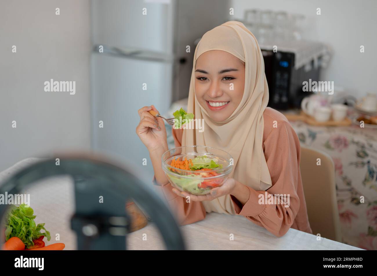 A beautiful Asian Muslim female food blogger or content creator is ...