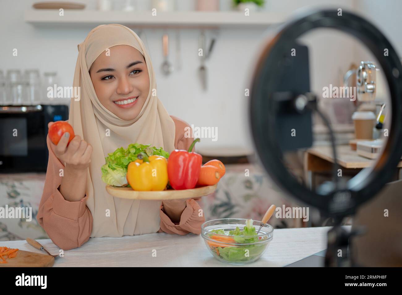A beautiful Asian Muslim female food blogger or lifestyle influencer is ...