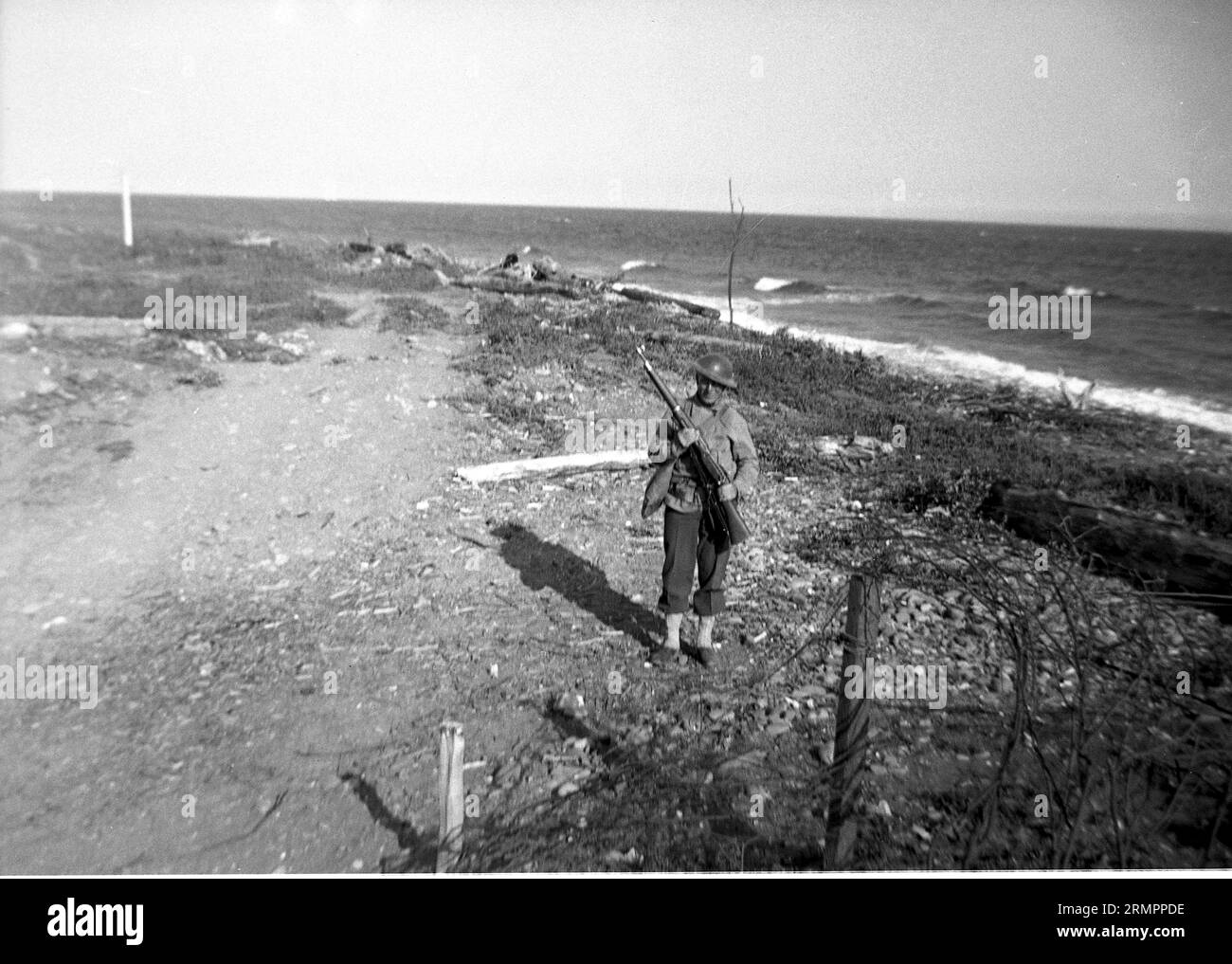 Soldier holding bolt action rifle near ocean. Members of the United ...