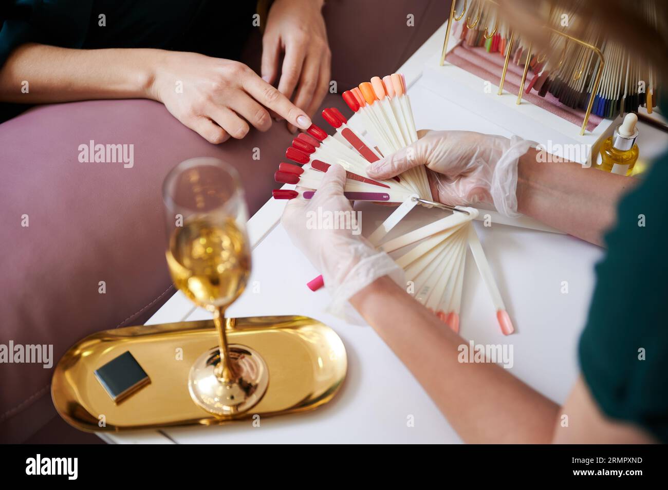 Close up of female hand pointing at red color nail sample while ...