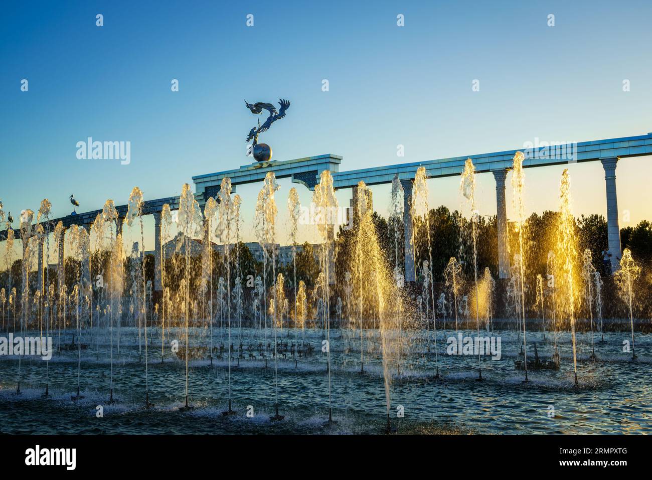 Memorial and rows of fountains illuminated by sunlight at sunset or ...