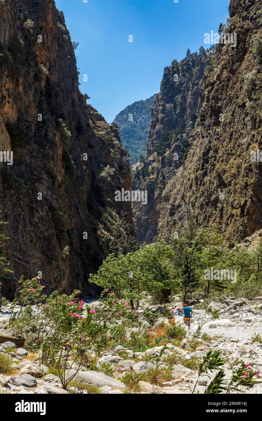 Hikers in a narrow gorge with huge, towering cliffs either side ...