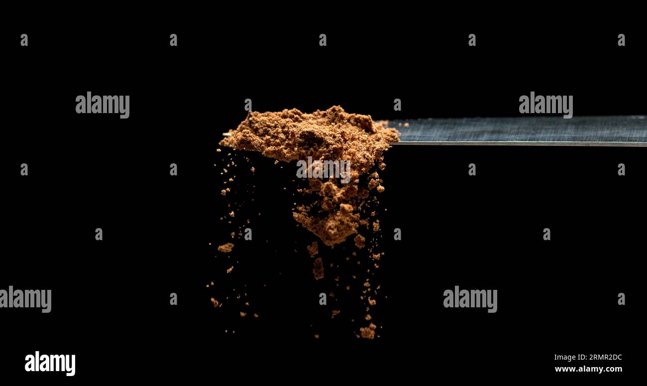 Nutmeg, myristica fragans, Powder falling from Spoon against Black ...