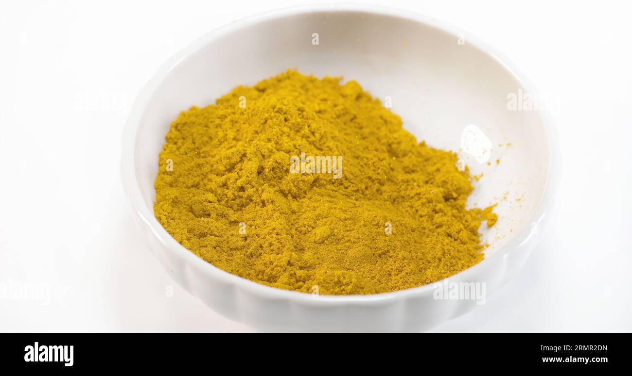 Curry Powder falling against white background Stock Photo - Alamy