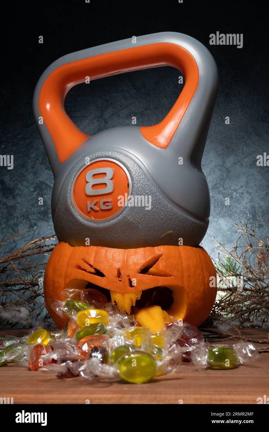Kettlebell crushing carved Halloween pumpkin Jack-o'-lantern. Candy ...