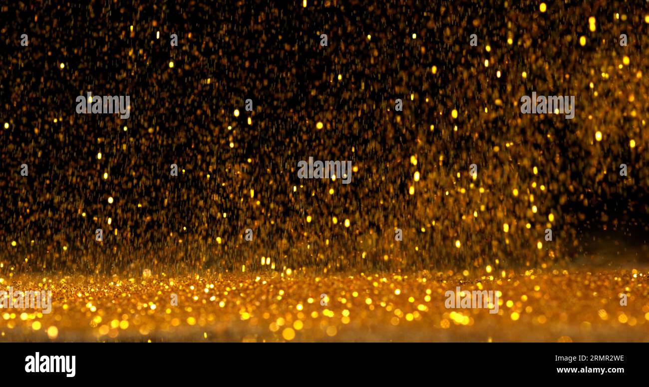 Gold Powder falling against Black Background Stock Photo - Alamy