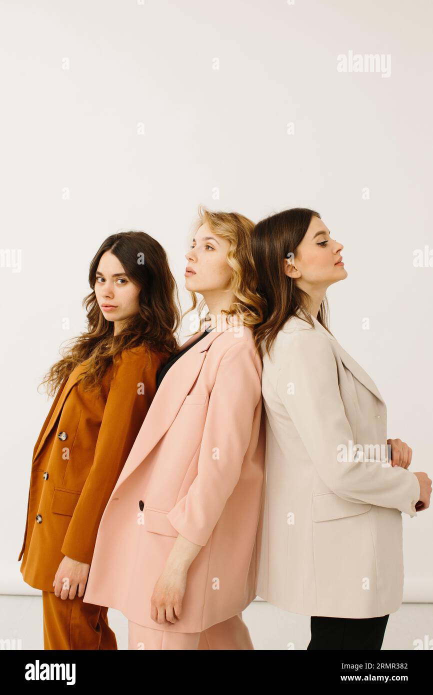 Stylish young women in pastel outfits standing together, fashion ...