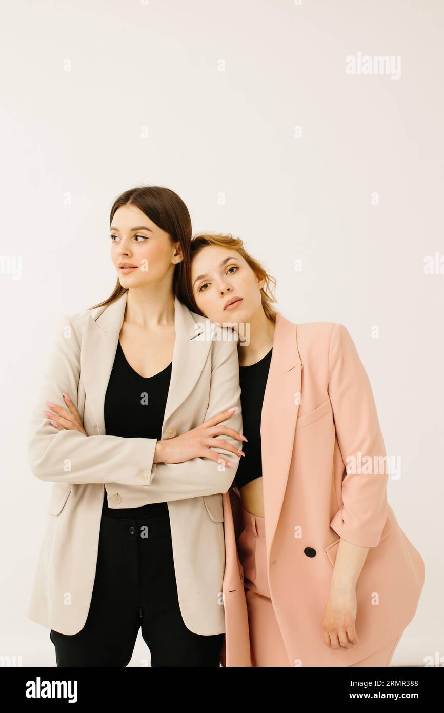 Stylish young women in pastel outfits standing together, fashion ...