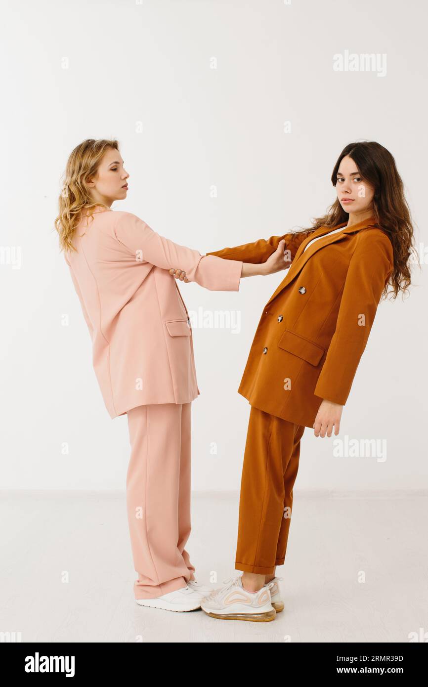 Stylish young women in pastel outfits standing together, fashion ...