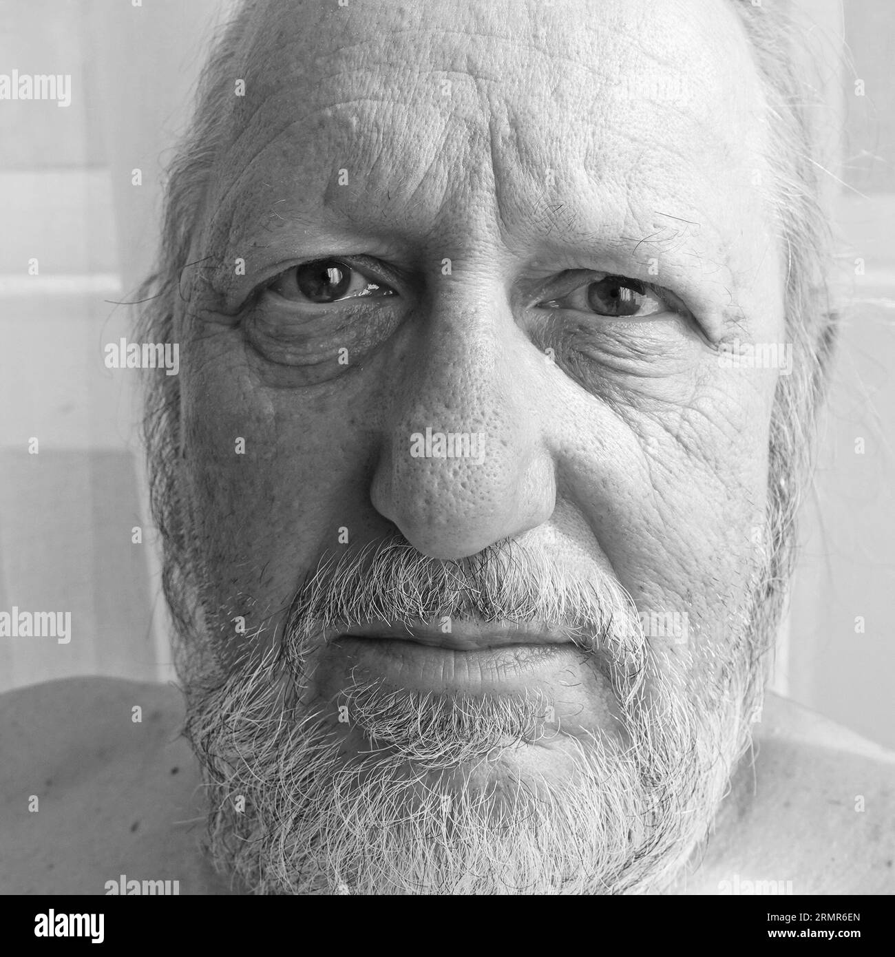 Black and white portrait of a serious looking man of 70 with a light ...