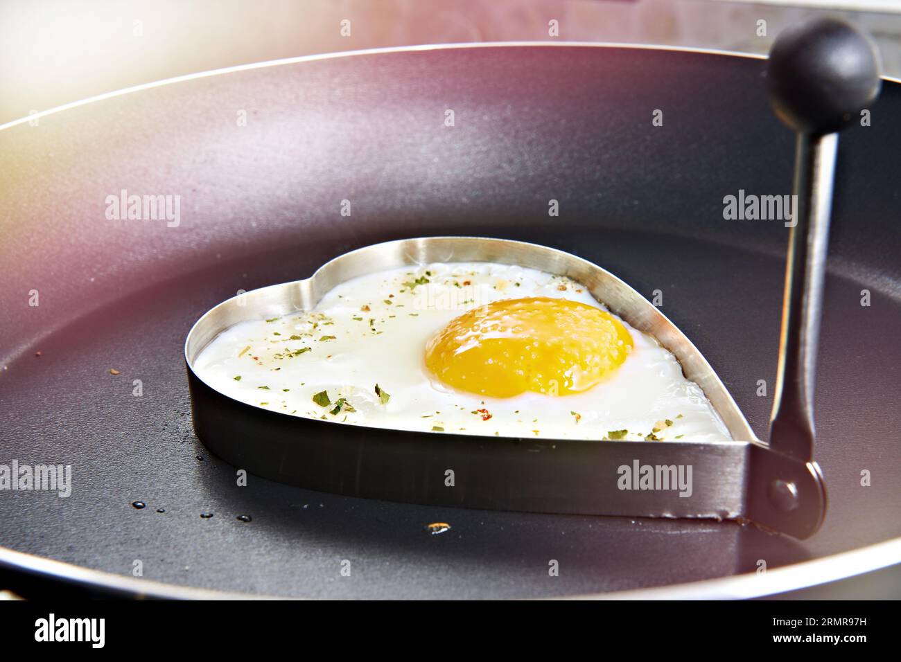 Preparing fried eggs in heart form breakfast Stock Photo - Alamy