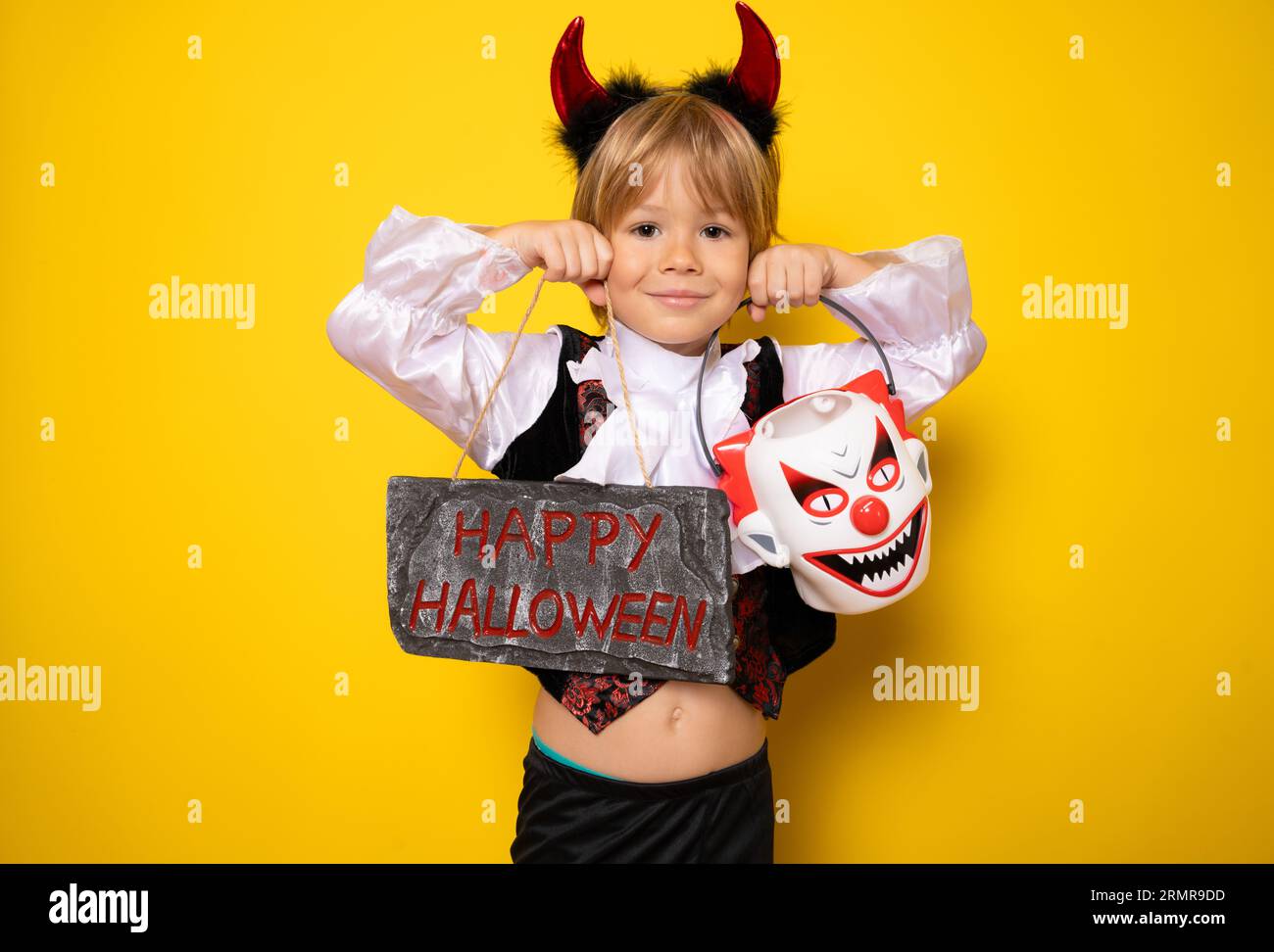 little boy dressed as a vampire on halloween isolated over yellow ...