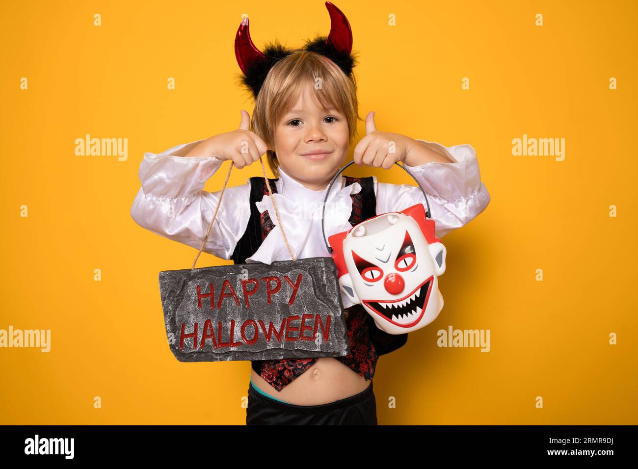 little boy dressed as a vampire on halloween isolated over yellow ...