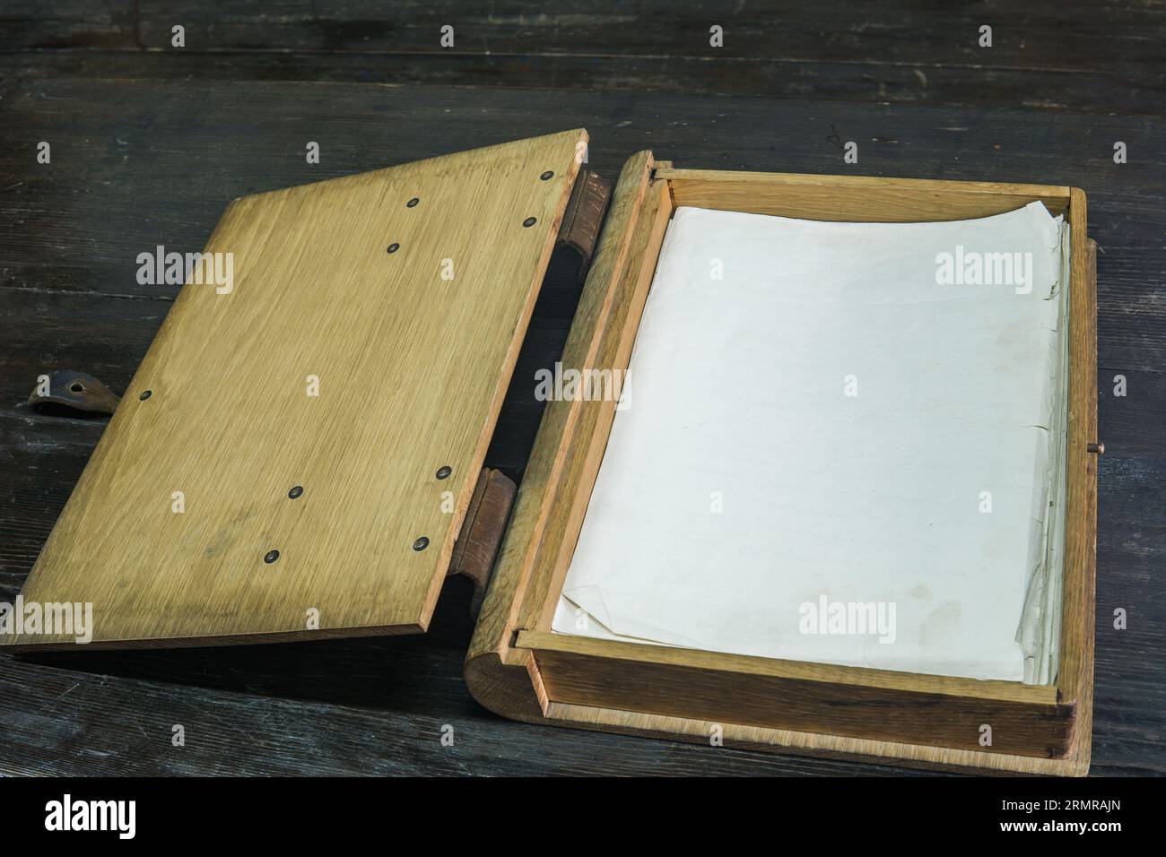 old log book in a wooden case with clasps on a black tabletop, opened ...
