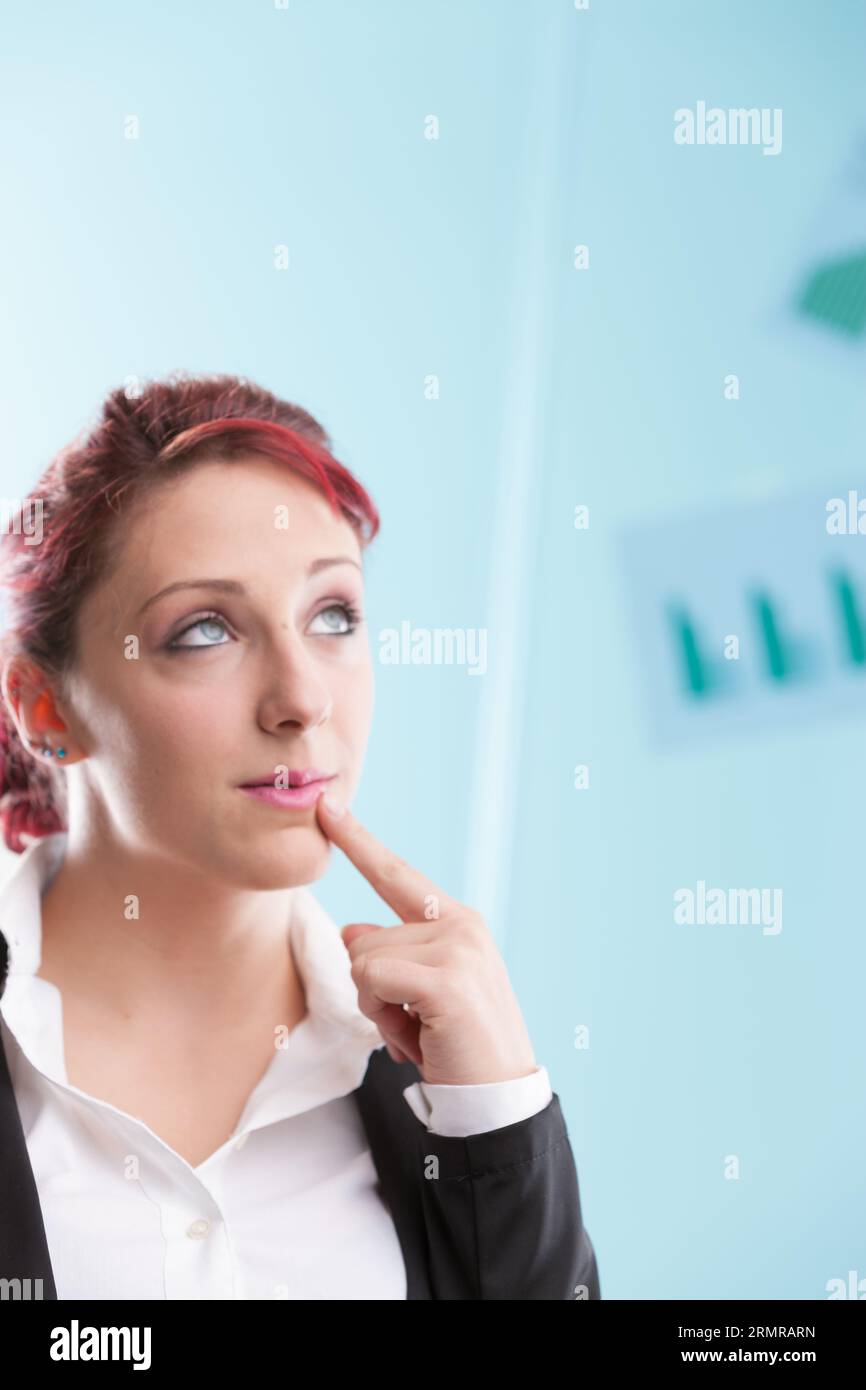 Red-haired young lady, donning a formal suit and unbuttoned white shirt ...