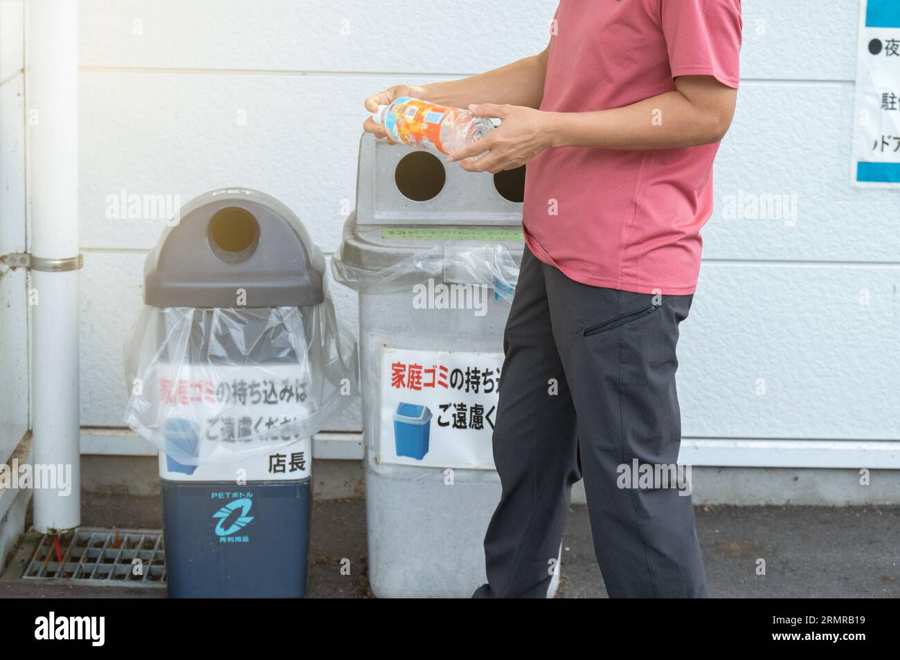 People throwing a plastic bottle in to a recycle bin. Women sorting ...