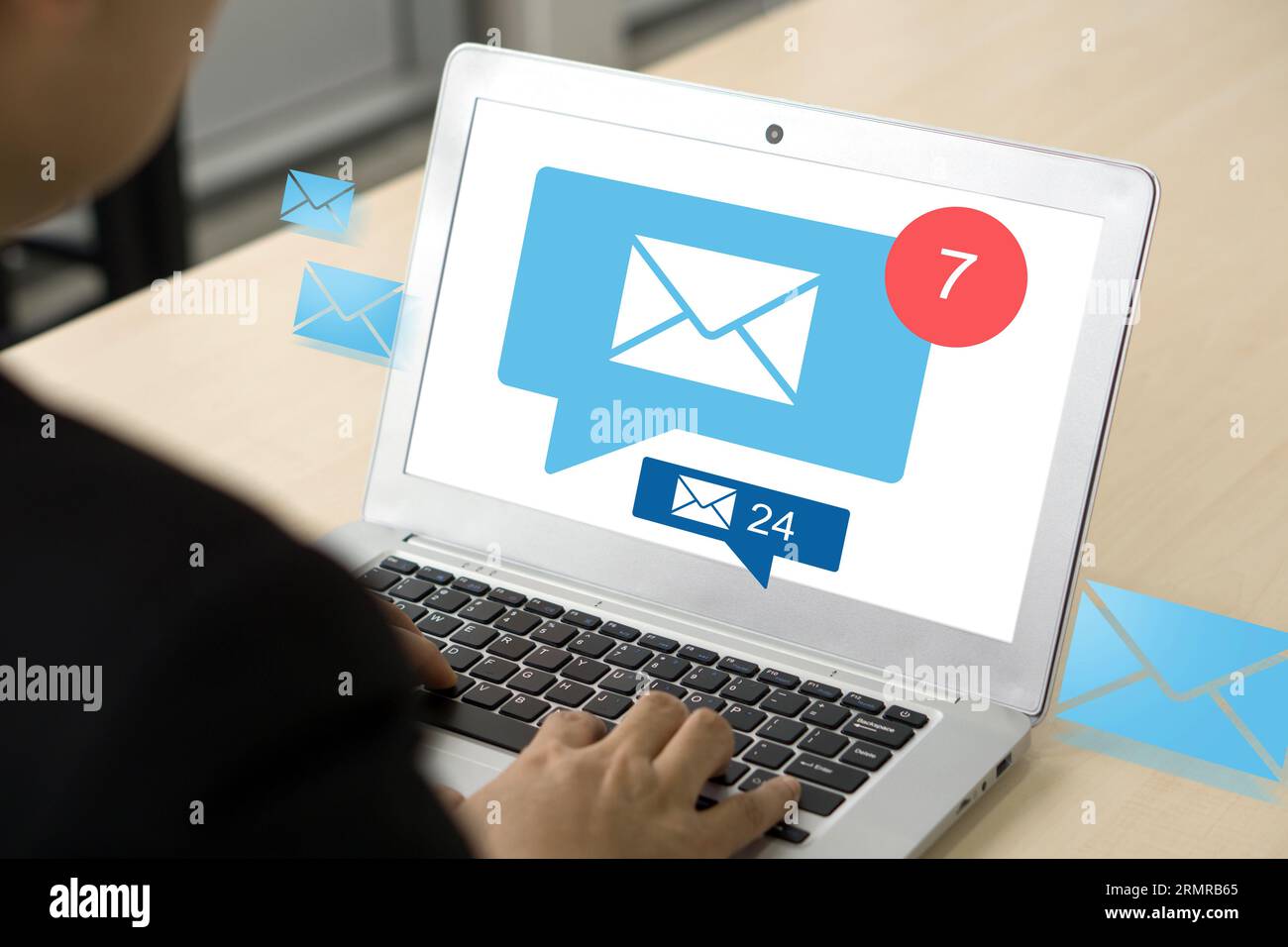 Focused man engrossed with laptop screen highlighted by email icon ...