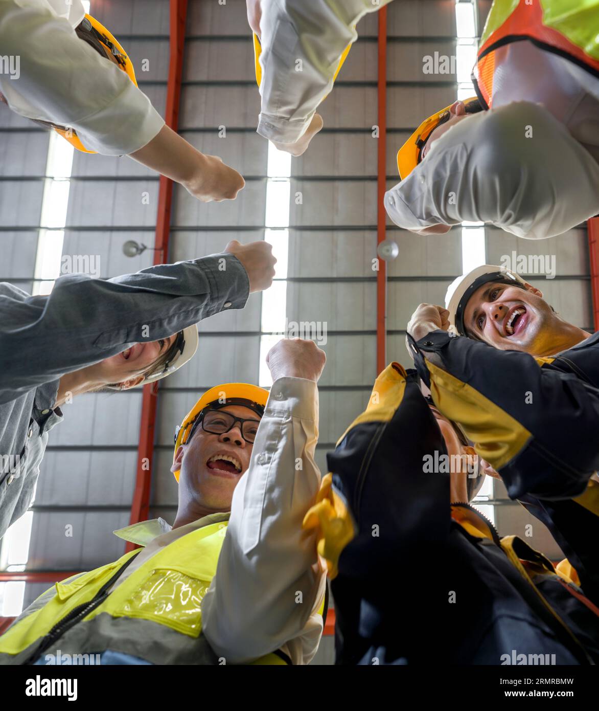 Celebrating Success: Hardhat construction workers raising their hands ...