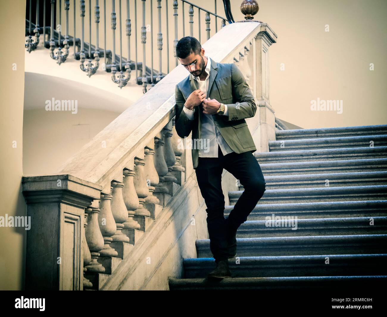 A man in a suit is walking down a set of stairs. Photo of a man ...