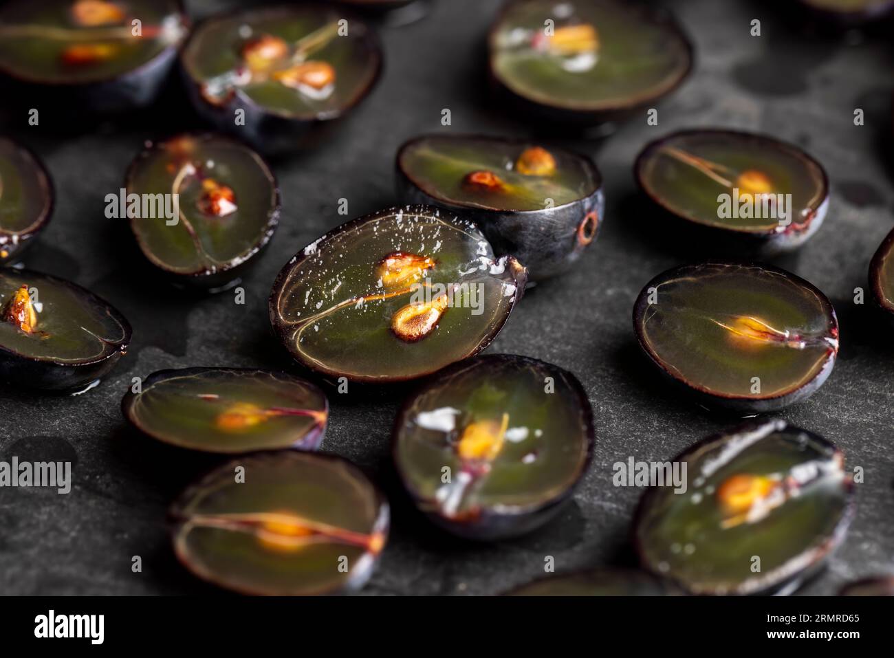 sweet ripe black grapes cut in half, wet dark grapes cut into pieces ...