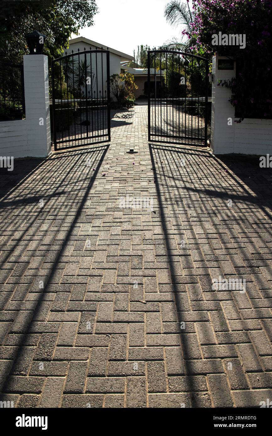 The shadows from a pair of half open, black, sinister, wrought iron ...