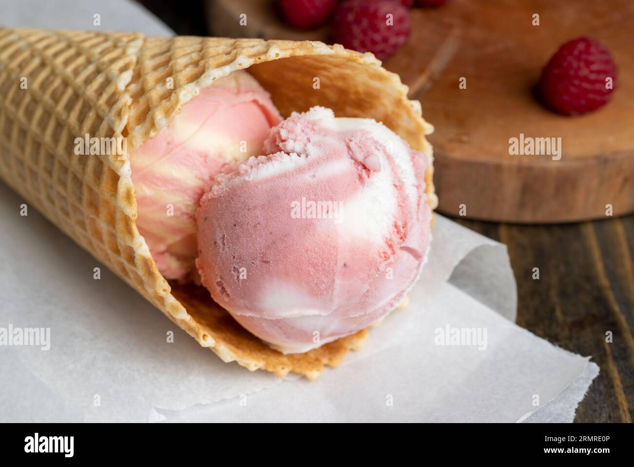 Waffle cone with white pink cream ice cream and raspberries, raspberry ...