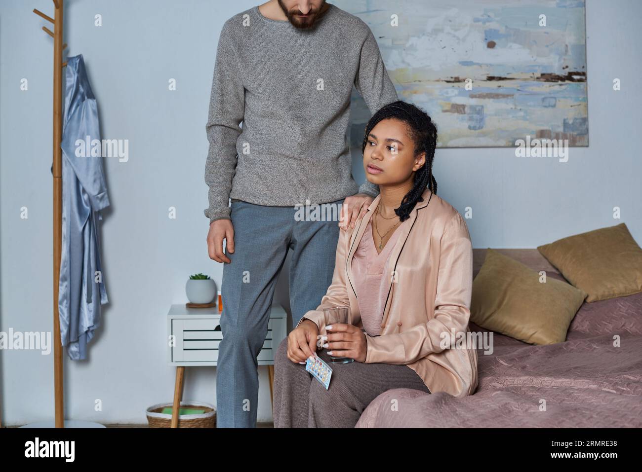 pregnancy planning, man standing near african american woman, glass of ...