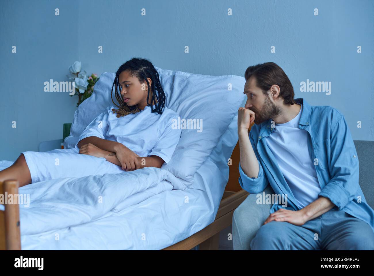 Man Grieving Near Depressed African American Wife Hospital Ward