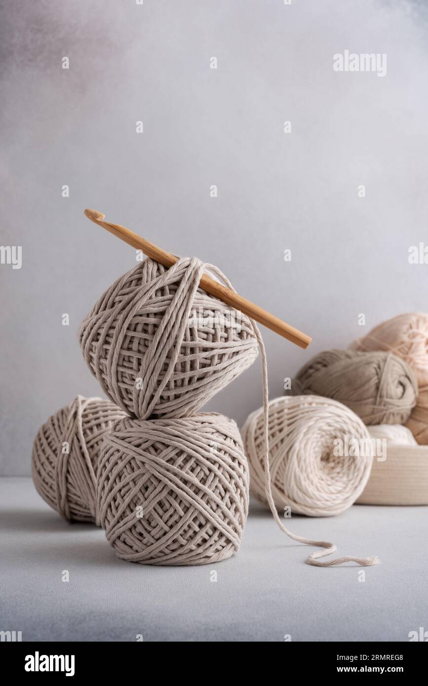 Stack of cotton threads pastel color skeins and wooden hook for craft ...