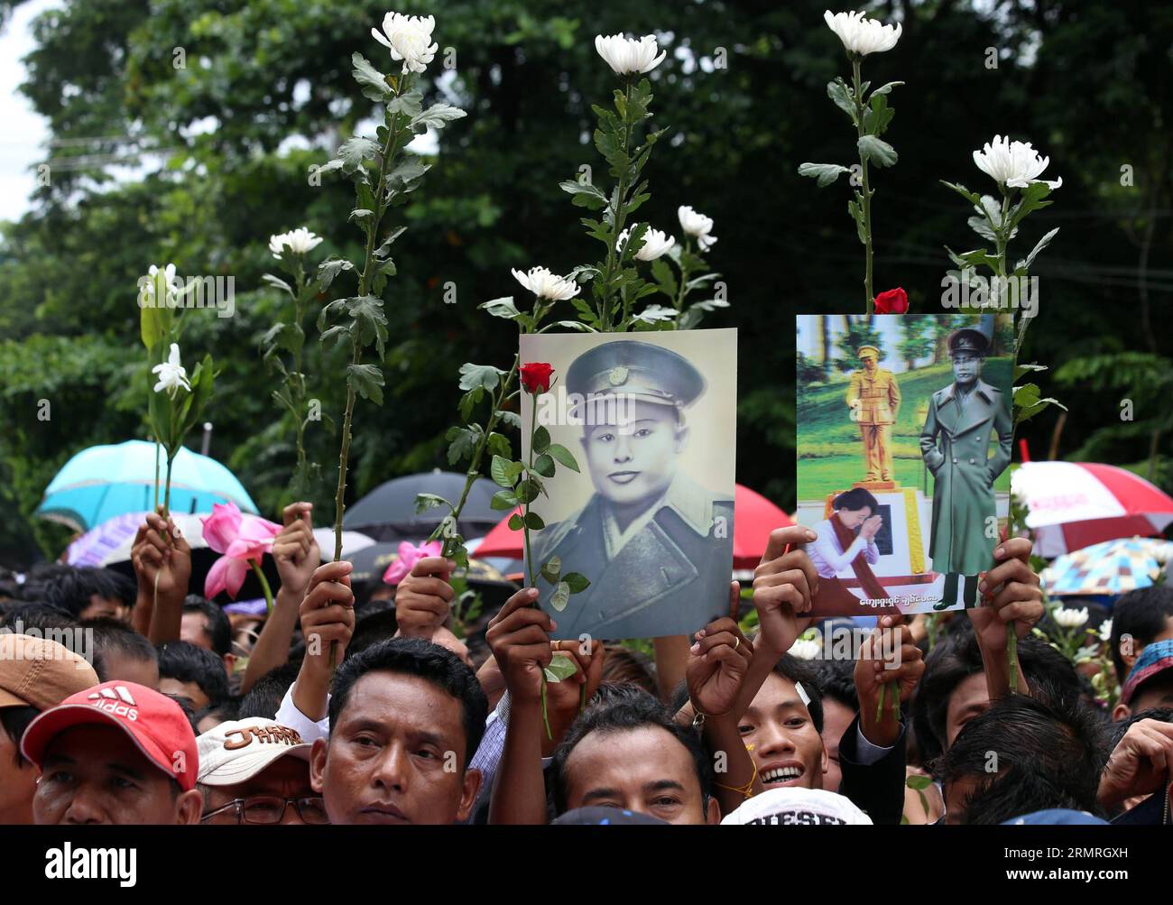 People hold pictures of martyrs during the 67th Martyrs Day ceremony ...