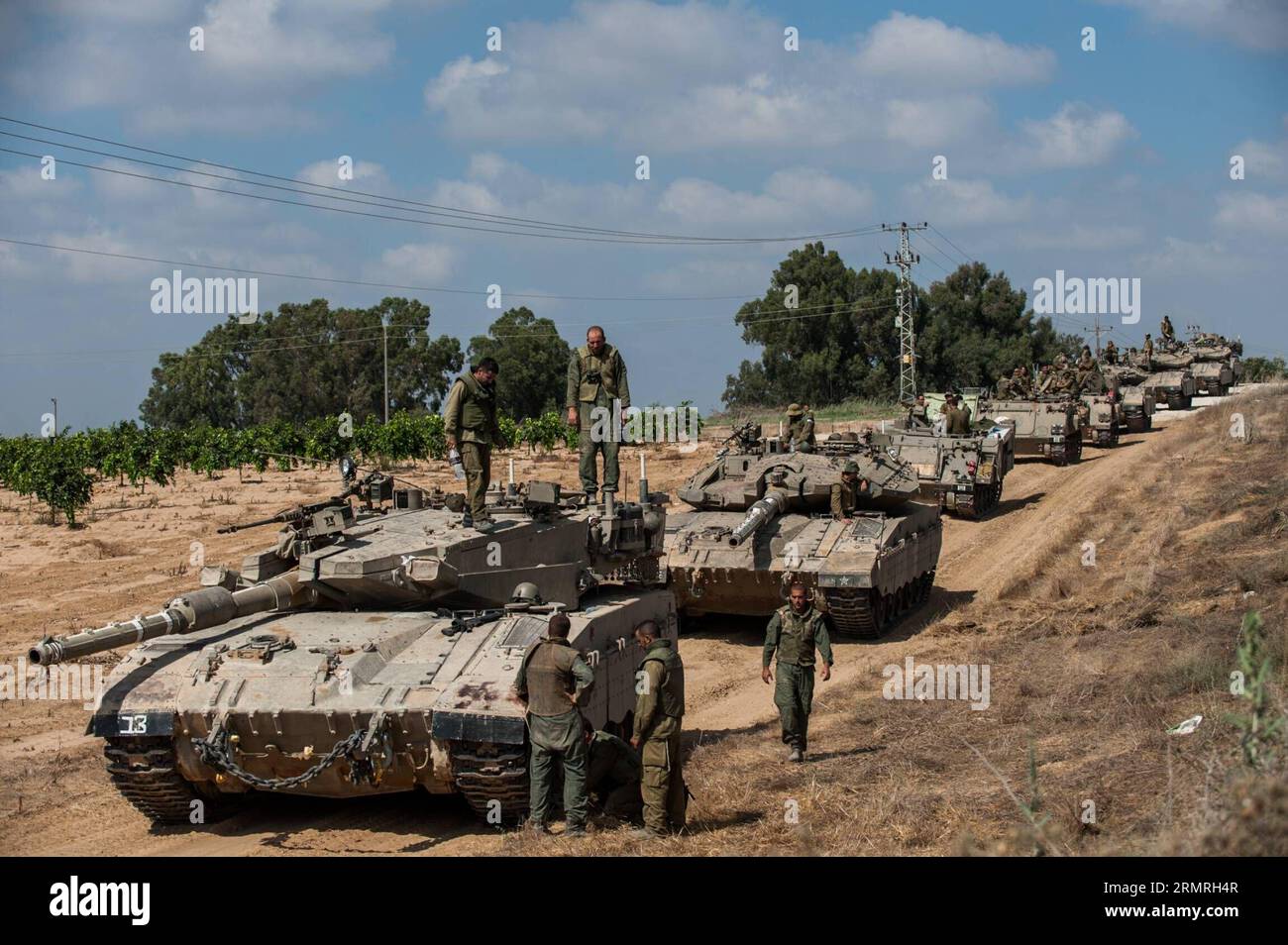 Israeli armored vehicles are seen in the field in southern Israel near ...